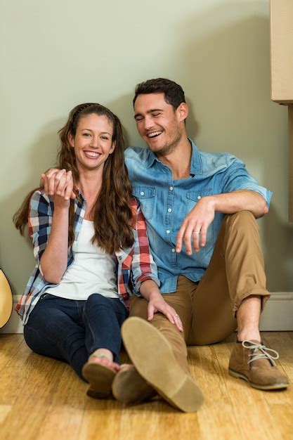 Pareja De Jóvenes Sentados Juntos En El Piso Y Sonriendo En Su Nueva