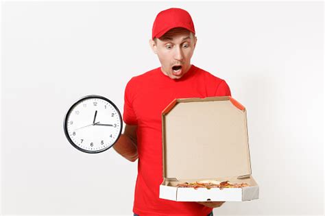 흰색 배경에 고립 된 빨간 유니폼에 배달 남자 남성 모자 티셔츠 골 판지 Flatbox 및 시계 이탈리아 피자를 들고 택배로 일하고 있는 시간에 보여주는 광고에 대 한