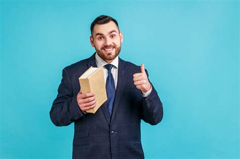 엄지 손가락을 들고 책을 읽고 장르와 플롯을 좋아하는 추천 엄지 손가락을 보여주는 공식 스타일 정장을 입고 미소 긍정적 인 남성 25 29세에 대한 스톡 사진 및 기타