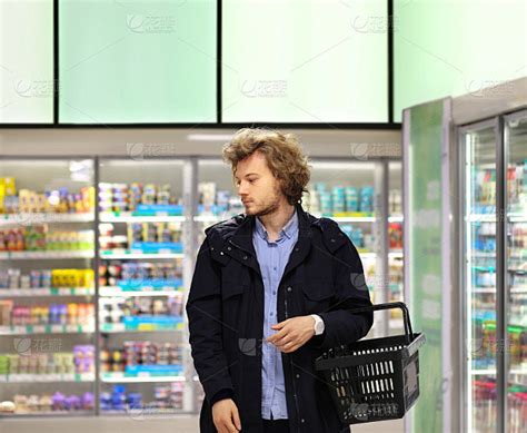 从超市冰箱里挑选冷冻食品的人