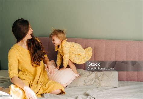 작은 유아 딸이 침대에서 뛰어 올라 돌보는 어머니와 놀고 있습니다 18 23 개월에 대한 스톡 사진 및 기타 이미지 18 23 개월 2명 30 34세 Istock