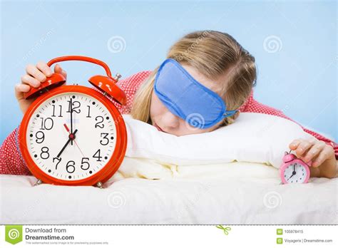 Pyjamas De Port De Femme De Sommeil Tenant Lhorloge Image Stock