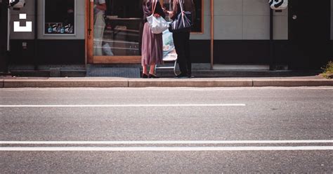 흰색 긴팔 셔츠와 파란색 데님 청바지를 입은 여자가 매장 앞에 서 있다 사진 Unsplash의 무료 일본 이미지