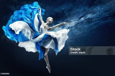 밤하늘 배경 위에 파란색 쉬폰 드레스를 입고 춤을 추는 발레리나 발레 댄서가 손을 가리키는 펄럭이는 치마를 입고 점프합니다 골동품 여신으로서의 판타지 여자 발레에 대한 스톡
