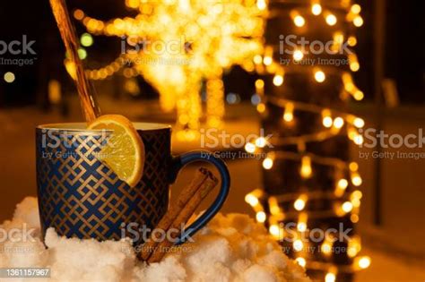 겨울 밤에 는 눈 속에서 레몬과 계피 한 조각을 들고 차 한 잔을 붓고 밝은 나무를 배경으로 붓습니다 차 뜨거운 음료에 대한 스톡 사진 및 기타 이미지 Istock