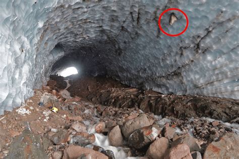 A Boulder Hanging In The Ice Ceiling Of The Cave And Melting Out
