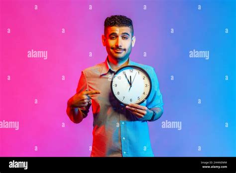 Look At Time Portrait Of Handsome Positive Man In Shirt Pointing Big Clock And Looking At
