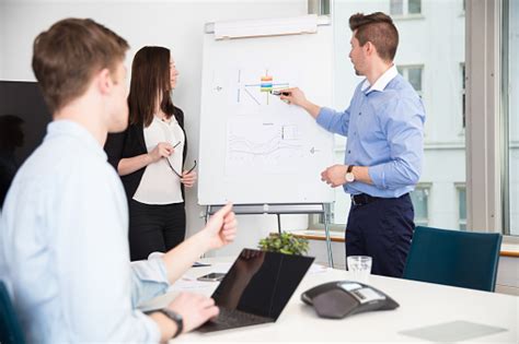 사무실에서 동료에 게 프레 젠 테이 션을 설명 하는 경영자 20 29세에 대한 스톡 사진 및 기타 이미지 20 29세 3 명 가리키기 Istock