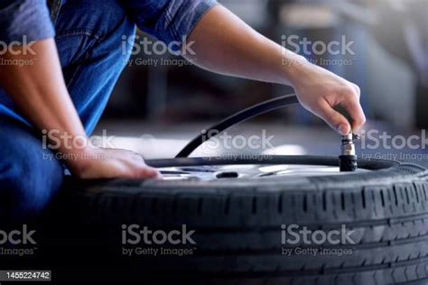 공기압 타이어 및 정비사는 펌프를 손에 들고 차고에서 작업합니다 자동차 서비스 차량 관리 및 작업장에서 자동차 바퀴를 확인하는 남자 모터 수리 산업에서 유지 보수 점검을