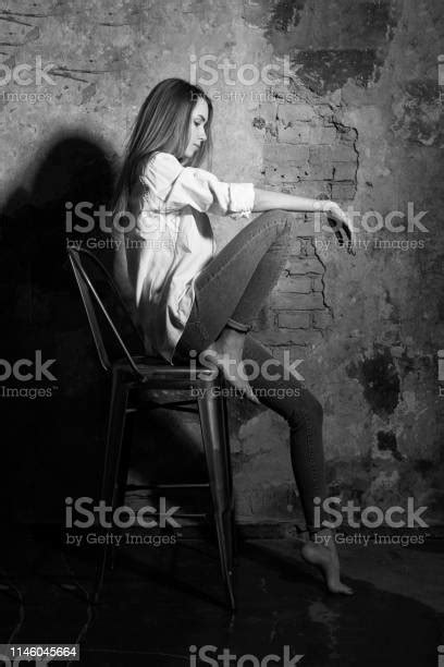 Gadis Muda Yang Menarik Atau Model Mengenakan Kemeja Duduk Di Kursi