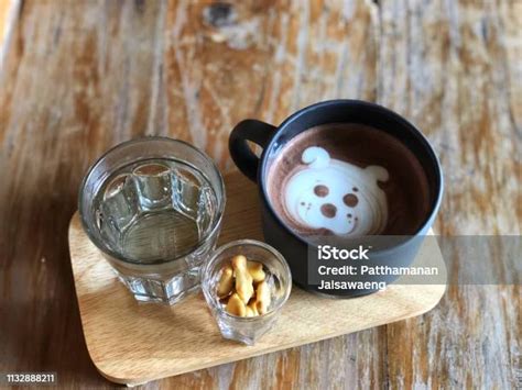 검은 컵과 나무 쟁반과 빈티지 나무 테이블 당신의 컵에 있는 라 떼 아트에 물 유리에 귀여운 강아지 얼굴 라 떼 아트를 제공 사랑 개 사랑 커피 복사 공간 및 평면도 0명에