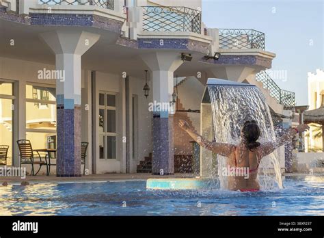 Woman Enjoying Under Jet Of Hydromassage Water With Gentle Splashes At