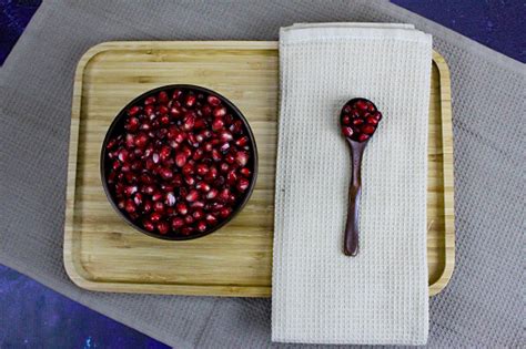 나무 그릇에 붉은 석류 씨앗과 냅킨 옆에 씨앗이 있는 나무 숟가락 나무 트레이에 붉은 석류 씨앗이 제공됩니다 0명에 대한 스톡 사진 및 기타 이미지 Istock