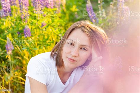 야외에서 미소 짓는 행복한 소녀 아름다운 젊은 브루넷 여자는 꽃이 피는 야생 꽃 녹색 배경으로 여름 필드에 휴식 무료 행복한 유럽 여성 긍정적 인 인간의 감정 얼굴 표정