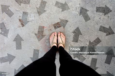 많은 방향 화살표 선택 콘크리트 바닥에 고립 된 골드 신발 평면도 서 있는 여자는 어떤 사용에 대 한 좋은 시멘트 바닥 배경에 플립 플롭 를 입고 발입니다 개인 장식품에