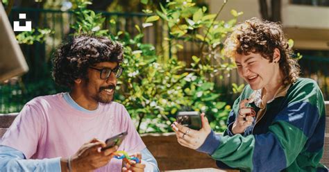 자폐증을 앓고 있는 두 명의 친구들이 밖에 앉아 스팀 장난감을 사용하고 휴대폰을 보며 웃고 있다 사진 Unsplash의 무료 행복한 이미지