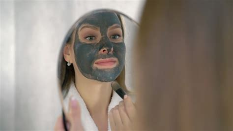 젊은 여성은 얼굴의 피부를 돌봅니다 소녀는 회색 점토 화장품 마스크를 착용 거울에 대한 스톡 사진 및 기타 이미지 거울 건강한 생활방식 깨끗한 Istock