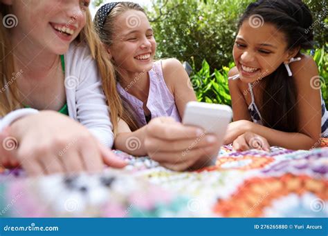 Once Upon A Giggle A Group Of Young Girls Chatting While Relaxing Outside With A Cellphone