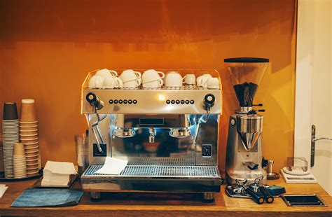 커피 숍에서 전문 커피 양조 바리 스타는 작은 카페에서 따뜻하고 아늑한 분위기의 커피 머신에서 커피 컵을 만듭니다