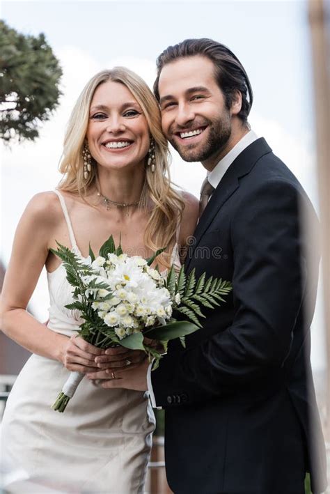Happy Newlyweds With Bouquet Smiling At Stock Image Image Of