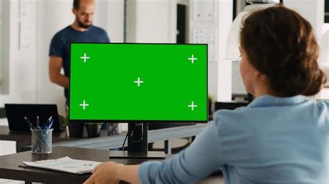Premium Photo Manager Working With Isolated Greenscreen On Computer At Workstation Looking At