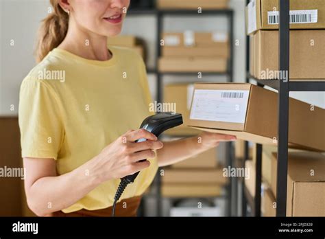 Cropped Shot Of Young Female Worker Of Warehouse Scanning Qr Codes On