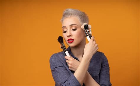 Premium Photo Thoughtful Young Woman With Make Up Brushes Standing