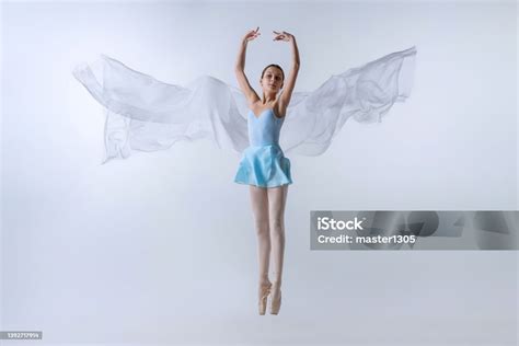 한 어린 소녀 파란 드레스를 입은 발레리나 지망생과 회색 배경에 고립 된 천으로 춤을 추는 것을 가리킨다 예술 은혜 아름다움 발레 학교 개념 12 13세에 대한 스톡 사진