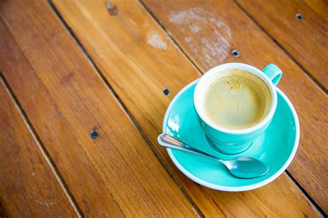 나무 테이블 배경에 접시와 녹색 컵에 뜨거운 커피 복사 공간이 있는 나무 배경에 커피 컵 나무 테이블에 거품이 있는 커피 한잔 갈색에 대한 스톡 사진 및 기타 이미지