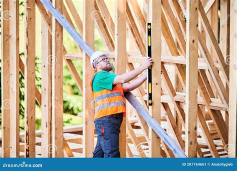 Carpenter Using Spirit Level While Constructing Wooden Frame House