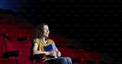 책을 들고 극장에 앉아 있는 여자 사진 Unsplash의 휴식 이미지