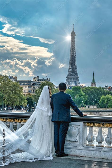 Un Couple De Jeunes Mariés Sur Le Pont Alexandre Iii à Paris Face à La
