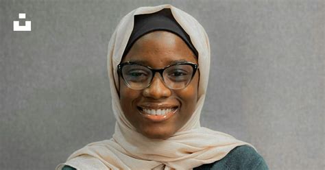 머리 스카프를 두른 여자가 카메라를 향해 미소를 짓고 있다 사진 Unsplash의 무료 나이지리아 이미지