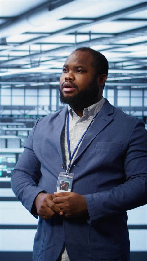 Vertical System Administrator Looking At Holograms In Data Center Monitoring Equipment