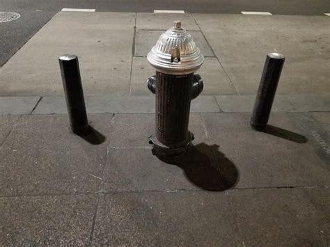Premium Photo High Angle View Of Fire Hydrant By Bollards On Footpath
