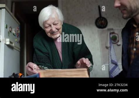 Grandmother And Grandson Are Looking At An Photograph Album Together