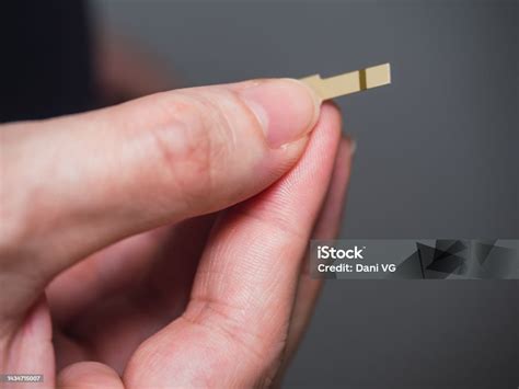 Womans Hand Holding Sheet To Measure Her Blood Sugar With Glucometer