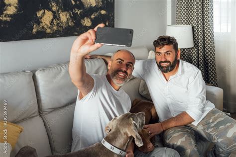 A Couple Of Men Of The Same Sex Making A Selfie In Their Living Room The Happy Smiling White