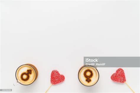 휘핑 우유 거품에 금성과 화성의 상징과 커피 두 컵과 흰색 탁상에 심장 모양의 커플 롤리팝 발렌타인 데이에 로맨틱 한 달콤한 아침 식사를 컨셉 플랫 레이 복사 공간 0명에