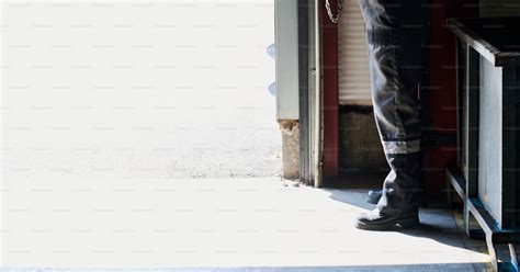 젊은 여성 엔지니어가 차고 격납고 또는 작업장의 셔터 롤러 도어를 열고 내부에 서서 긴 체인을 아래로 당깁니다 사진 Unsplash의 노동 이미지