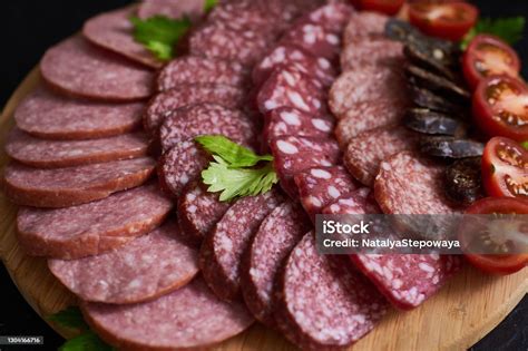 다른 맛의 모듬 슬라이스 소시지 허브와 체리 토마토가 있는 아름다운 나무 트레이에 담겨 제공됩니다 검은색에 대한 스톡 사진 및 기타 이미지 Istock