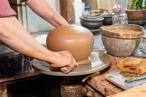 도자기 작업장 도예 개념 새로운 그릇을 만드는 사람의 손 도예가의 바퀴와 원시 가장자리로 작업하는 사람의 손가락 정면 클로즈업