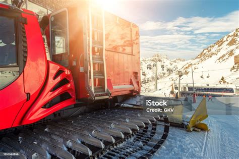 오스트리아의 알파인 스키 윈터 리조트 이쉬글에서 스키 슬로프 피스트 힐을 준비하는 스노우플러 스노우 그루밍 머신이 있는 레드 모던 스노우캣 트랙 중장비 산악 장비 트랙 차량