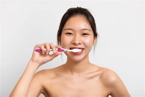 Premium Photo Portrait Of Young Asian Woman Brushing Her Teeth