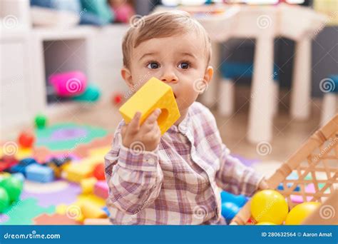 Adorable Caucasian Boy Sucking Construction Block At Kindergarten Stock