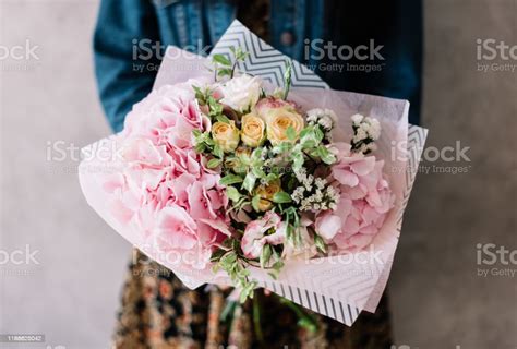 회색 벽 배경에 분홍색 색상의 신선한 수국 장미 유스토마 꽃의 아름다운 꽃다발을 들고 아주 좋은 젊은 여자 결혼식에 대한 스톡 사진 및 기타 이미지 Istock