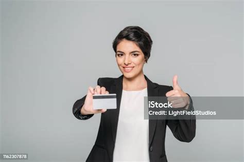 웃는 혼합 인종 사업가 신용 카드를 들고 회색에 고립 된 엄지 손가락을 보여주는 신용 카드에 대한 스톡 사진 및 기타 이미지 신용 카드 비즈니스 스튜디오 촬영