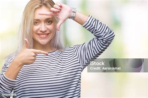 손으로 만드는 프레임 및 행복 한 얼굴로 손가락을 웃 고 고립 된 배경 위에 젊은 금발 여자 창의력과 사진 개념입니다 개념에