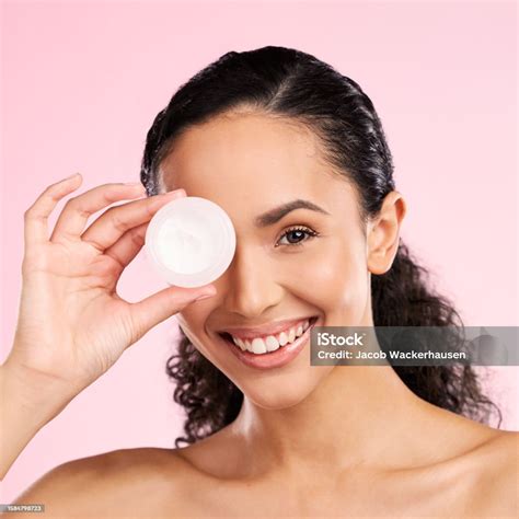 얼굴 스킨케어 그리고 분홍색 배경에 고립된 스튜디오에서 크림 용기를 든 행복한 여자 초상화 미용 및 모델 미소 모이스처라이저 자외선 차단제 화장품 또는 웰빙을 위한 피부과