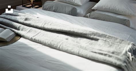 방에 하얀 시트와 베개가 있는 침대 사진 Unsplash의 무료 쿠션 이미지